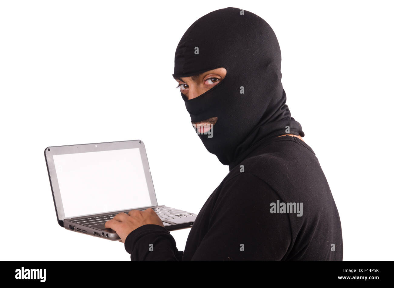 Hacker with computer wearing balaclava Stock Photo - Alamy