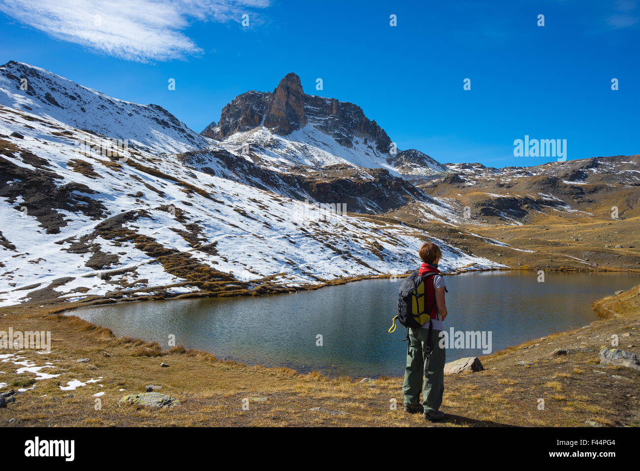 Hiker looking the outstanding view of high altitude blue lake and ...