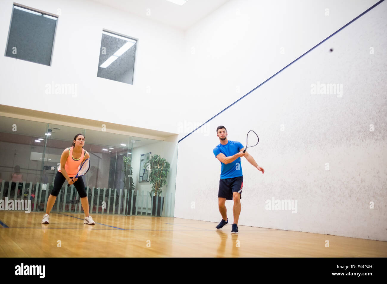 Couple playing a game of squash Stock Photo - Alamy
