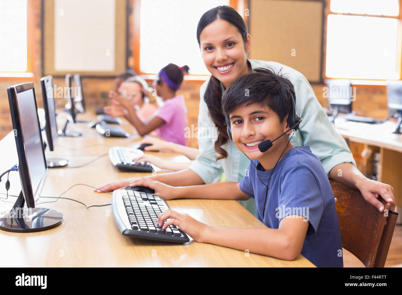 Cute pupils in computer class with teacher Stock Photo - Alamy