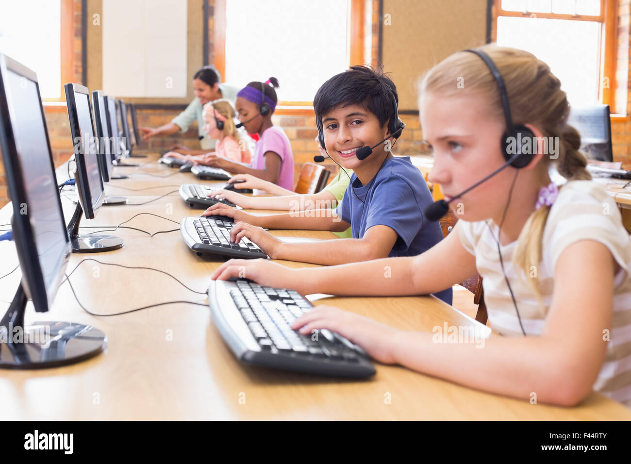 Cute pupils in computer class with teacher Stock Photo - Alamy