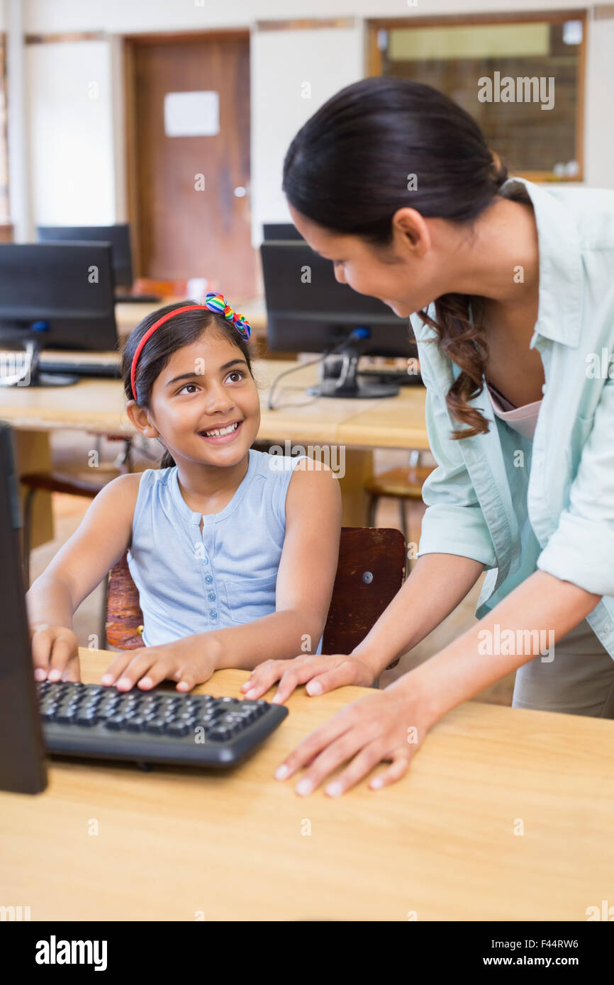 Cute pupil in computer class with teacher Stock Photo - Alamy