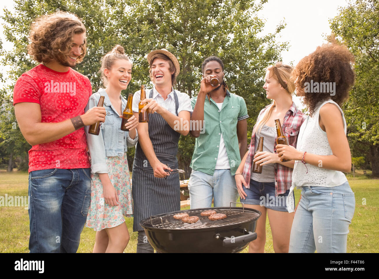 Happy friends in the park having barbecue Stock Photo - Alamy