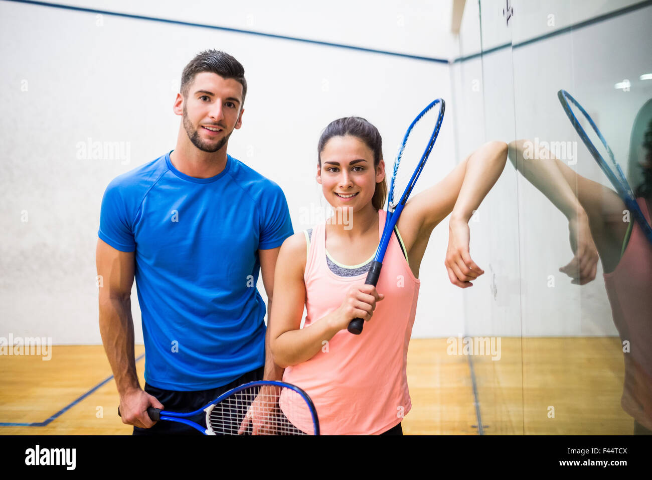 Happy couple about to play squash Stock Photo - Alamy