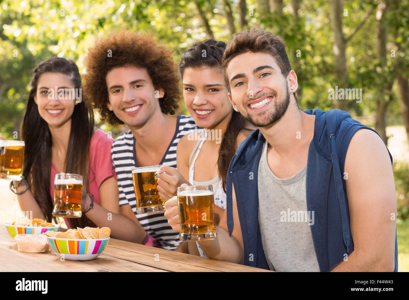Happy friends in the park having beers Stock Photo - Alamy