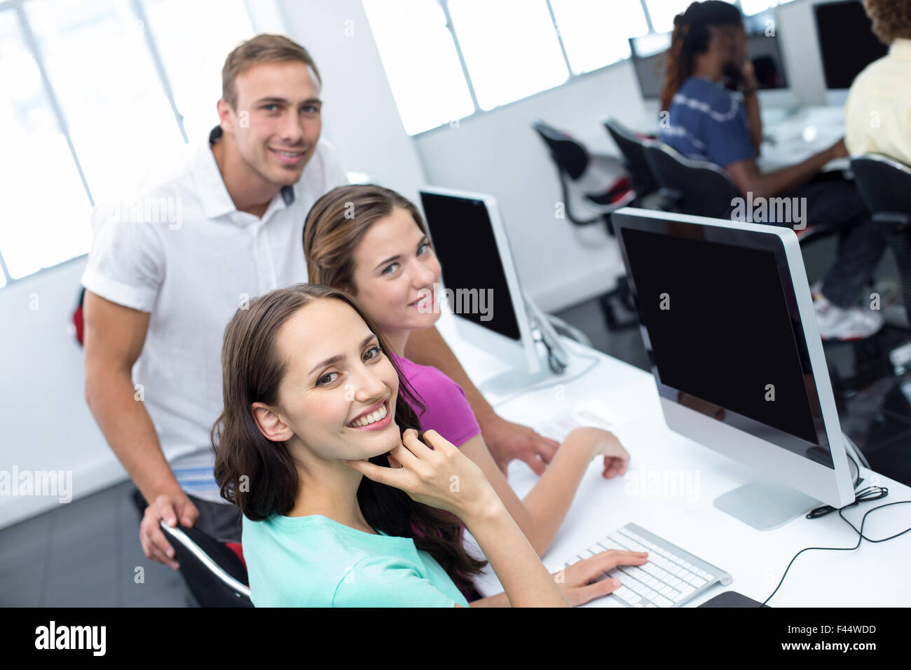 Computer teacher and pretty female students Stock Photo - Alamy
