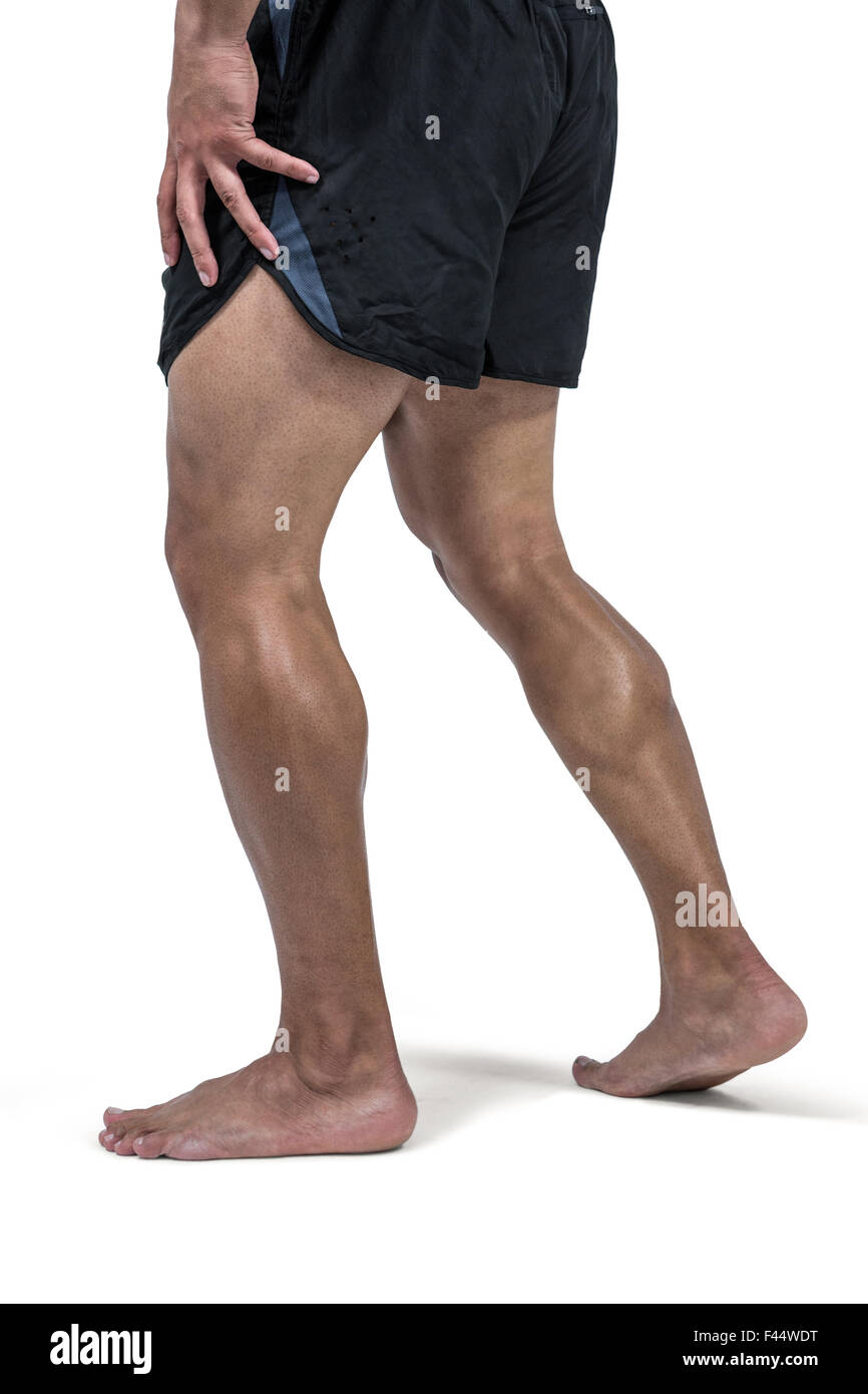Muscular man flexing leg for camera Stock Photo - Alamy