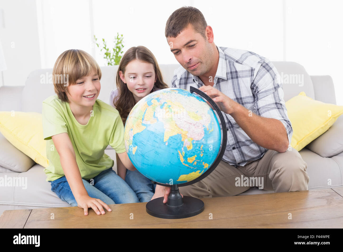 Family exploring globe Stock Photo - Alamy