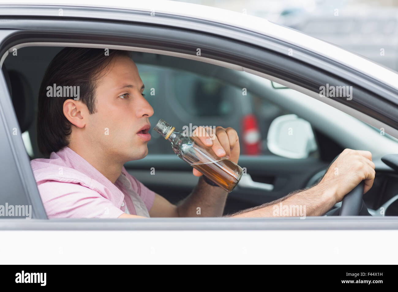 Man drinking alcohol while driving Stock Photo - Alamy