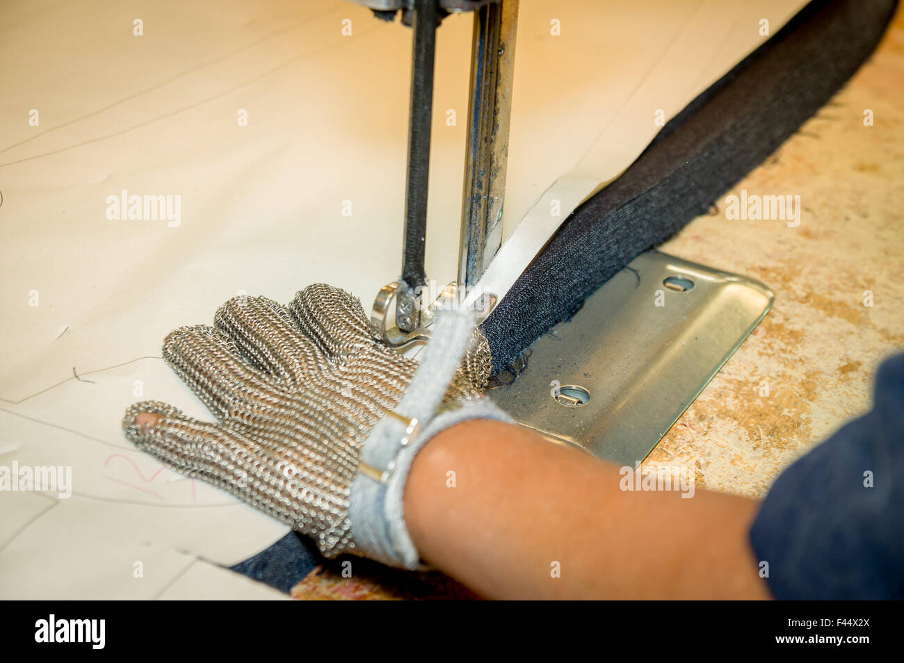 Hands wearing protection gloves using industrial machine for cutting ...