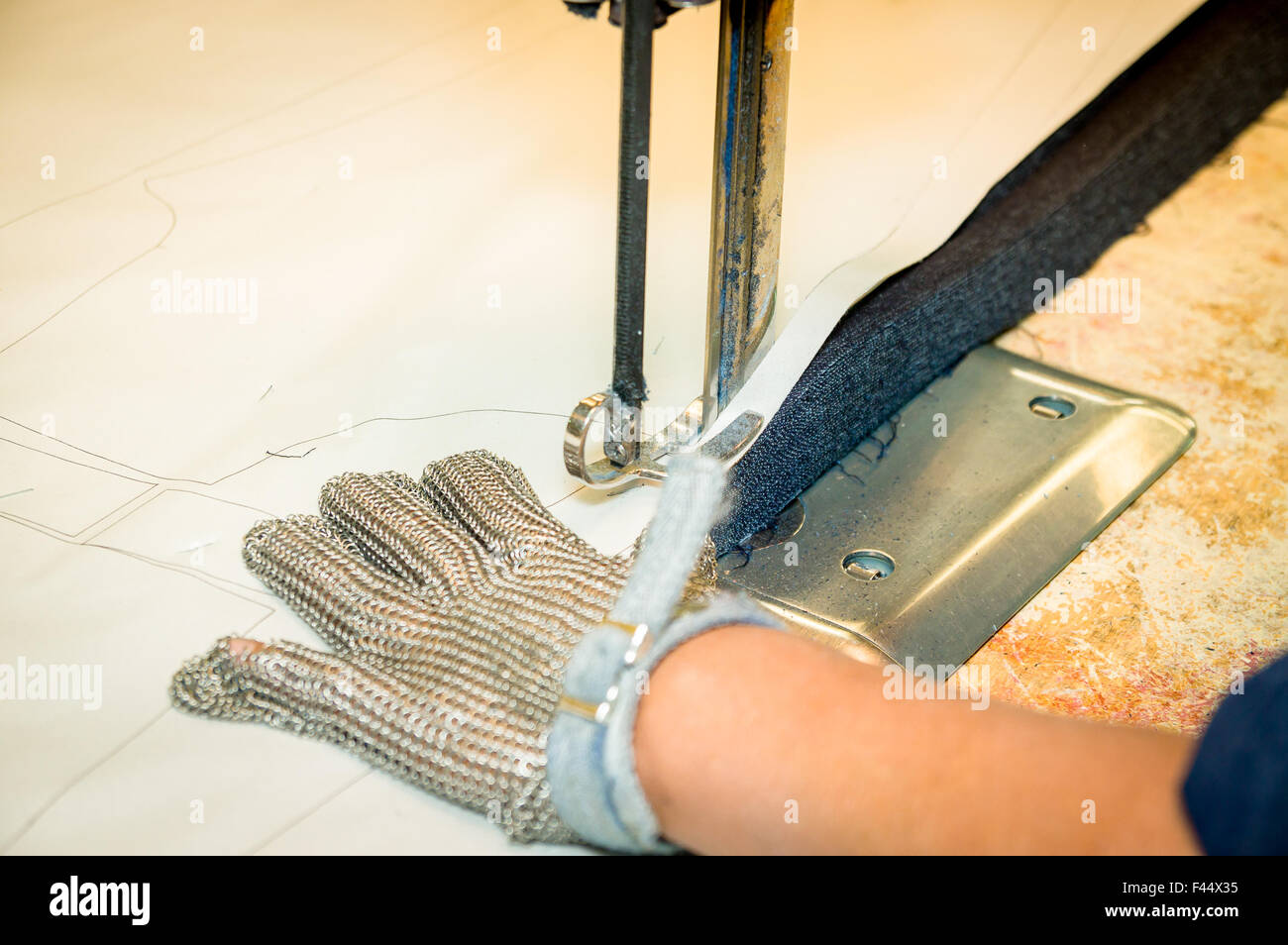 Hands wearing protection gloves using industrial machine for cutting ...