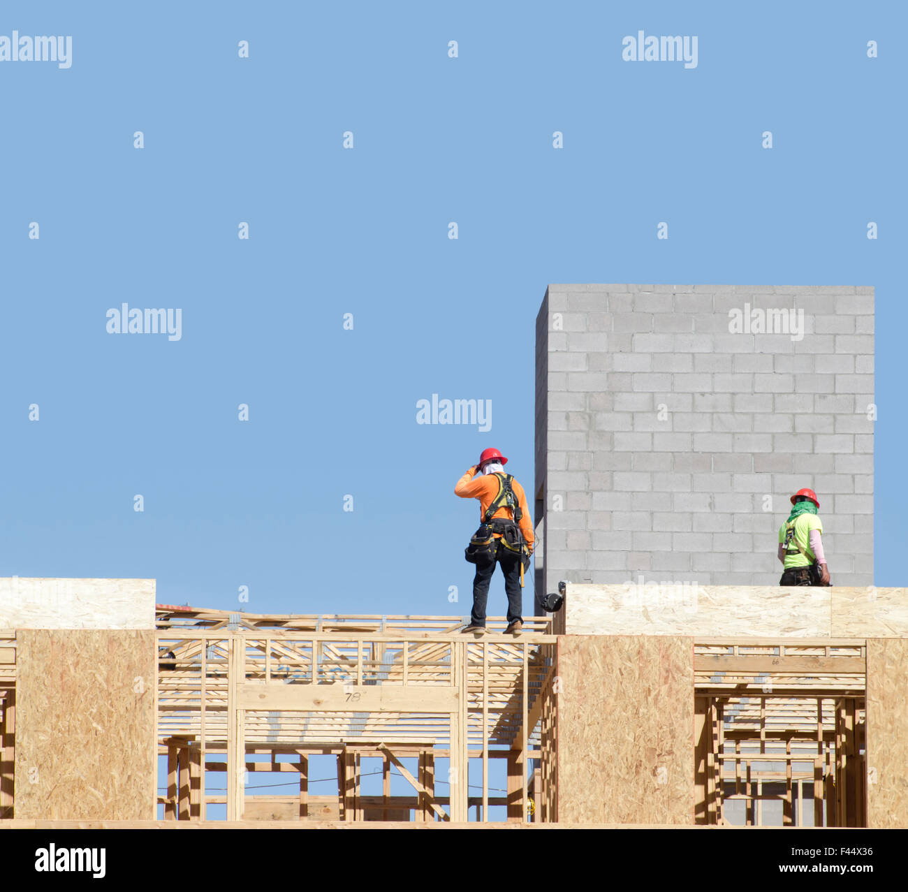 Construction crew working on the roof of a new, luxury apartment ...