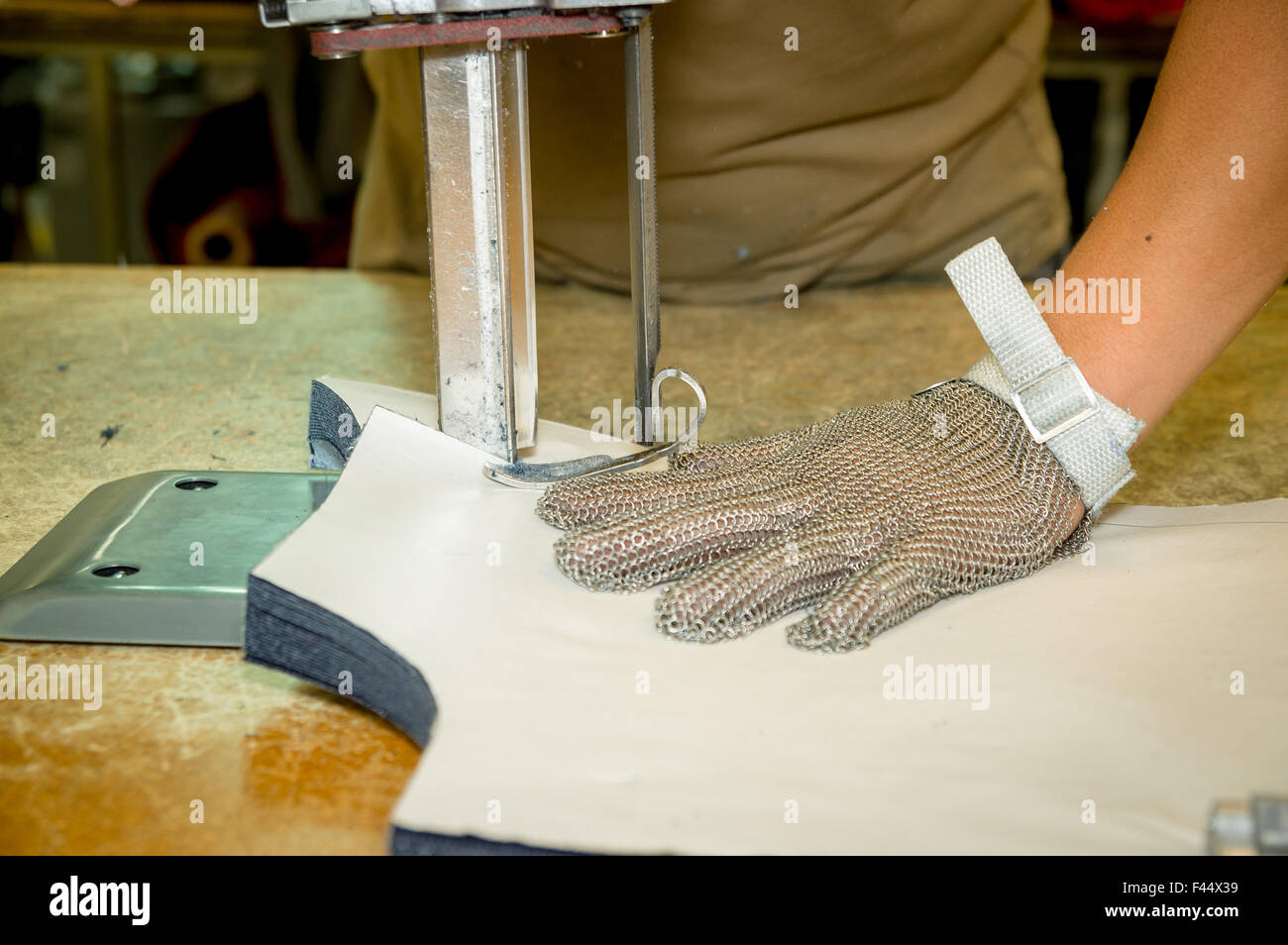Hands wearing protection gloves using industrial machine for cutting ...