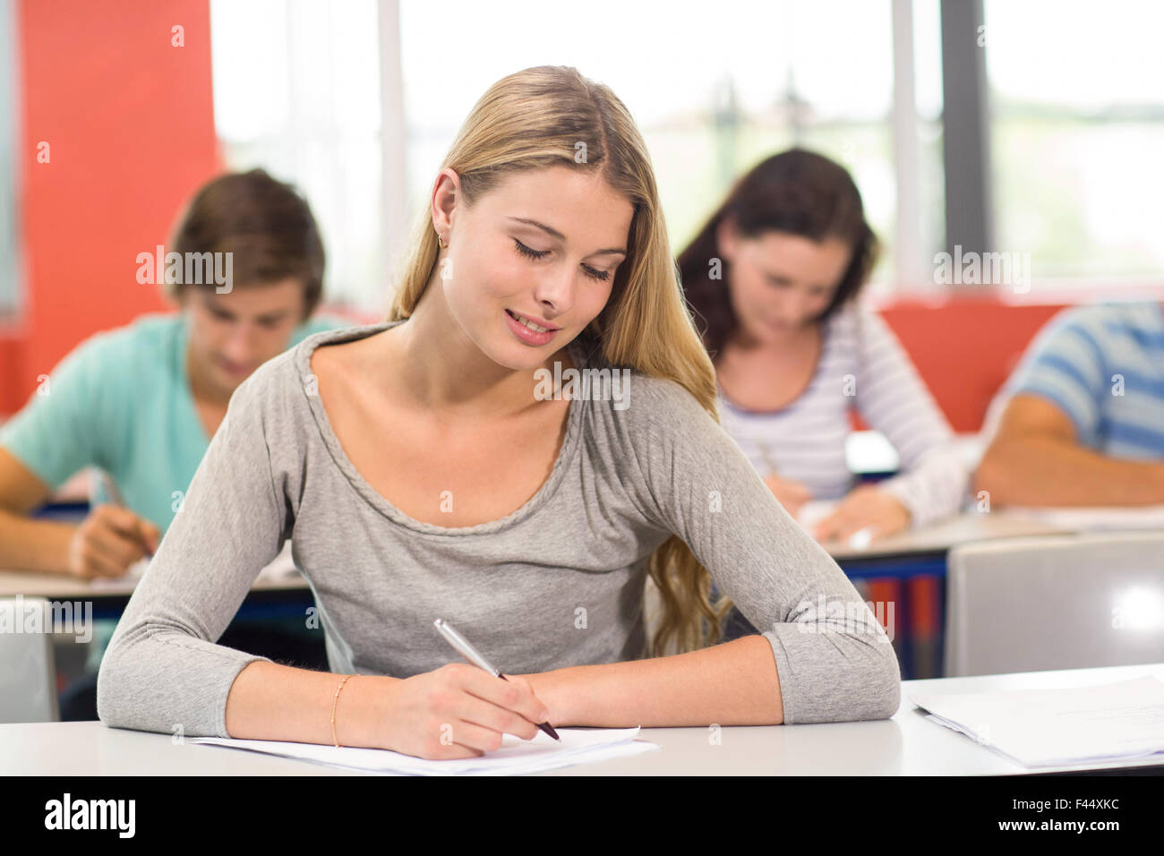Female student writing notes in classroom Stock Photo - Alamy