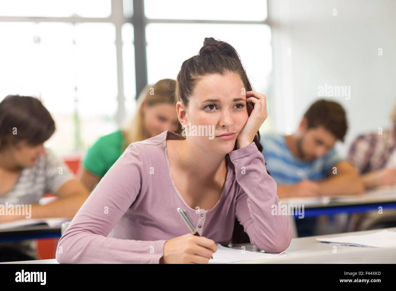 Female student writing notes in classroom Stock Photo - Alamy