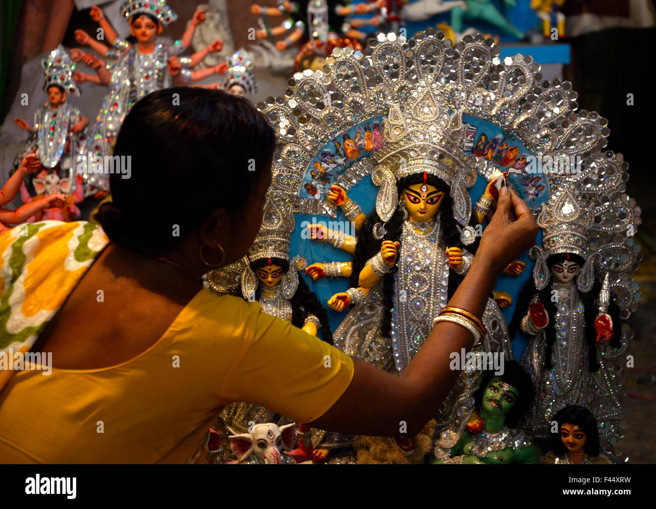 Kolkata, India. 14th Oct, 2015. A woman artist gives finishing touches ...