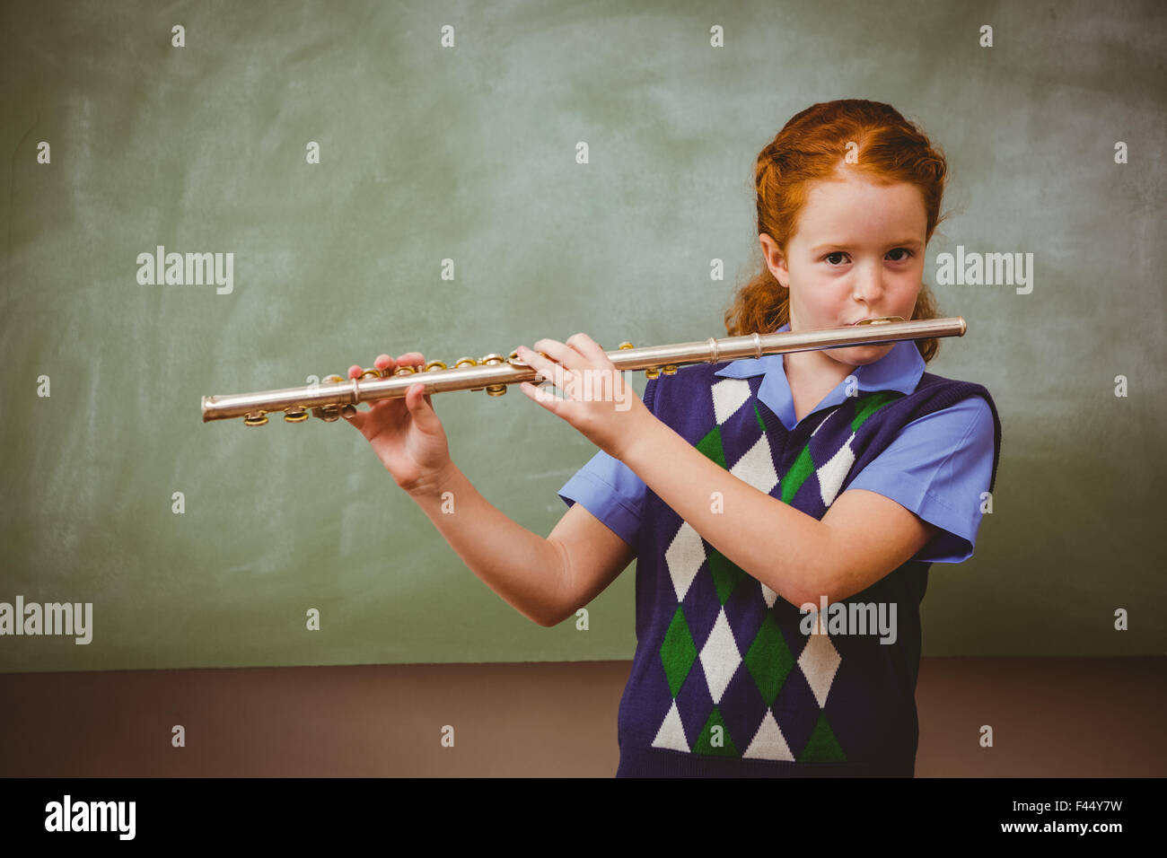 Cute little girl playing flute in classroom Stock Photo - Alamy