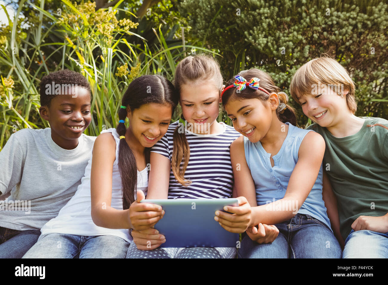 Children using digital tablet at park Stock Photo - Alamy