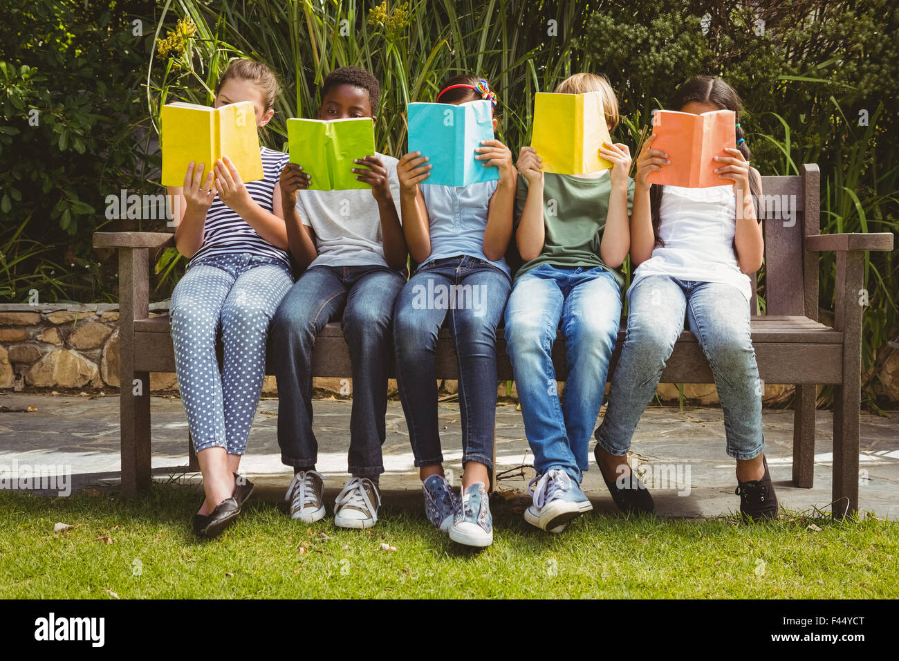 Children reading books at park Stock Photo - Alamy