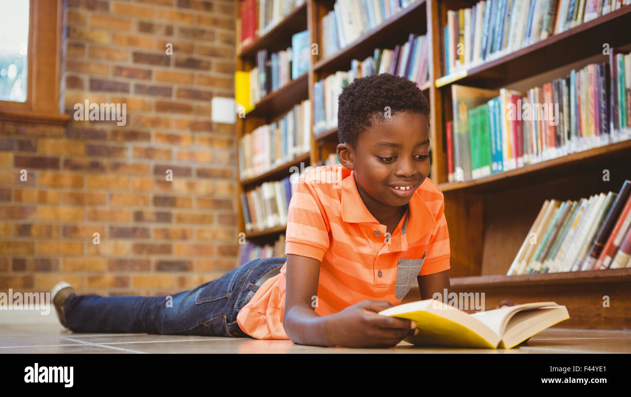 Cute boy reading book in library Stock Photo - Alamy