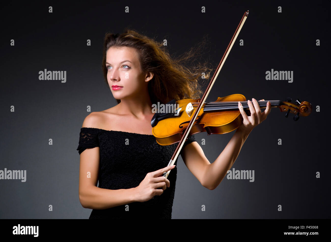 Female musical player against dark background Stock Photo - Alamy