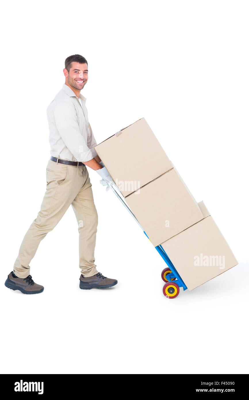 Happy delivery man pushing trolley of boxes Stock Photo - Alamy