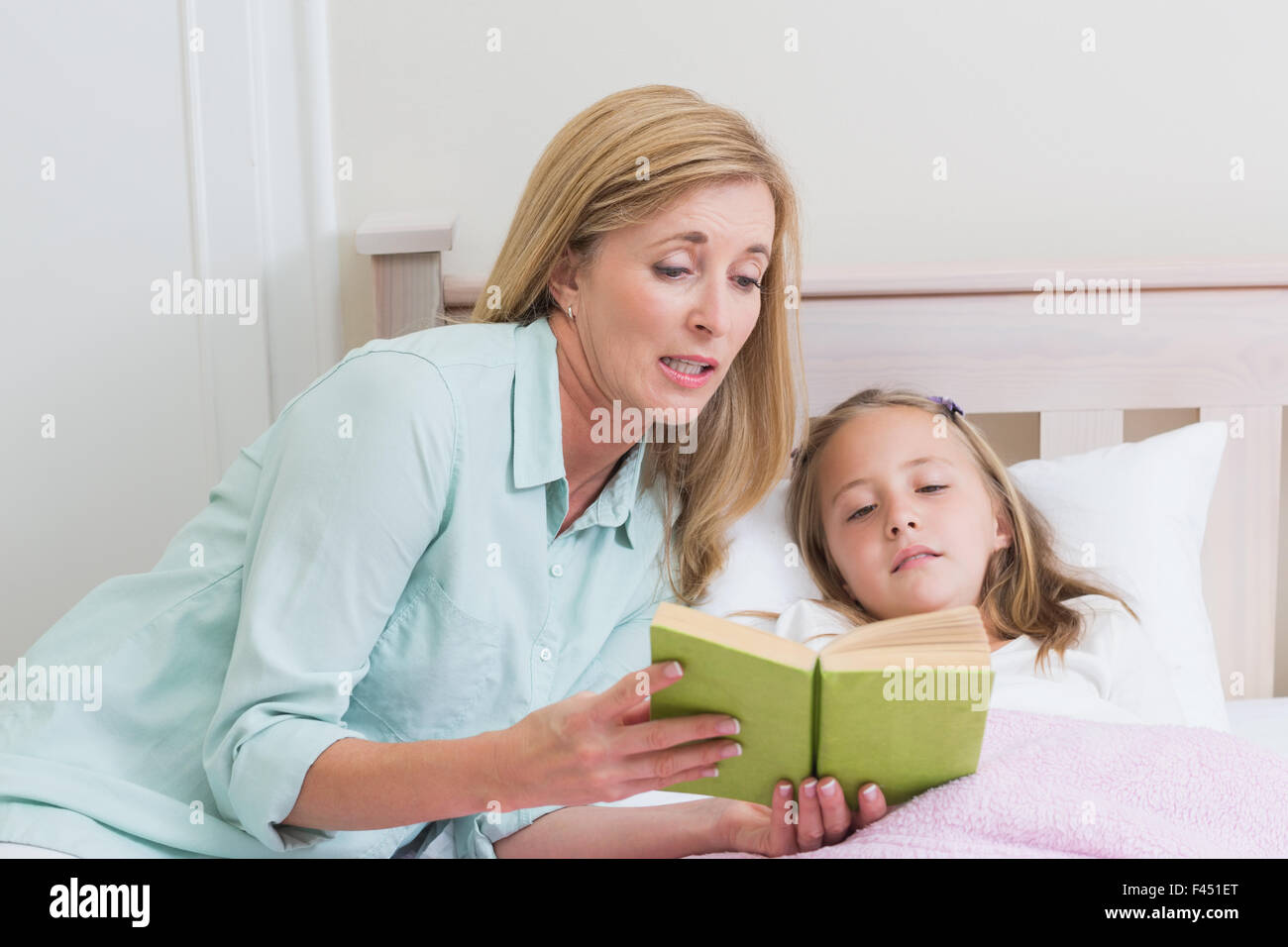 Happy mother and daughter reading a book Stock Photo - Alamy