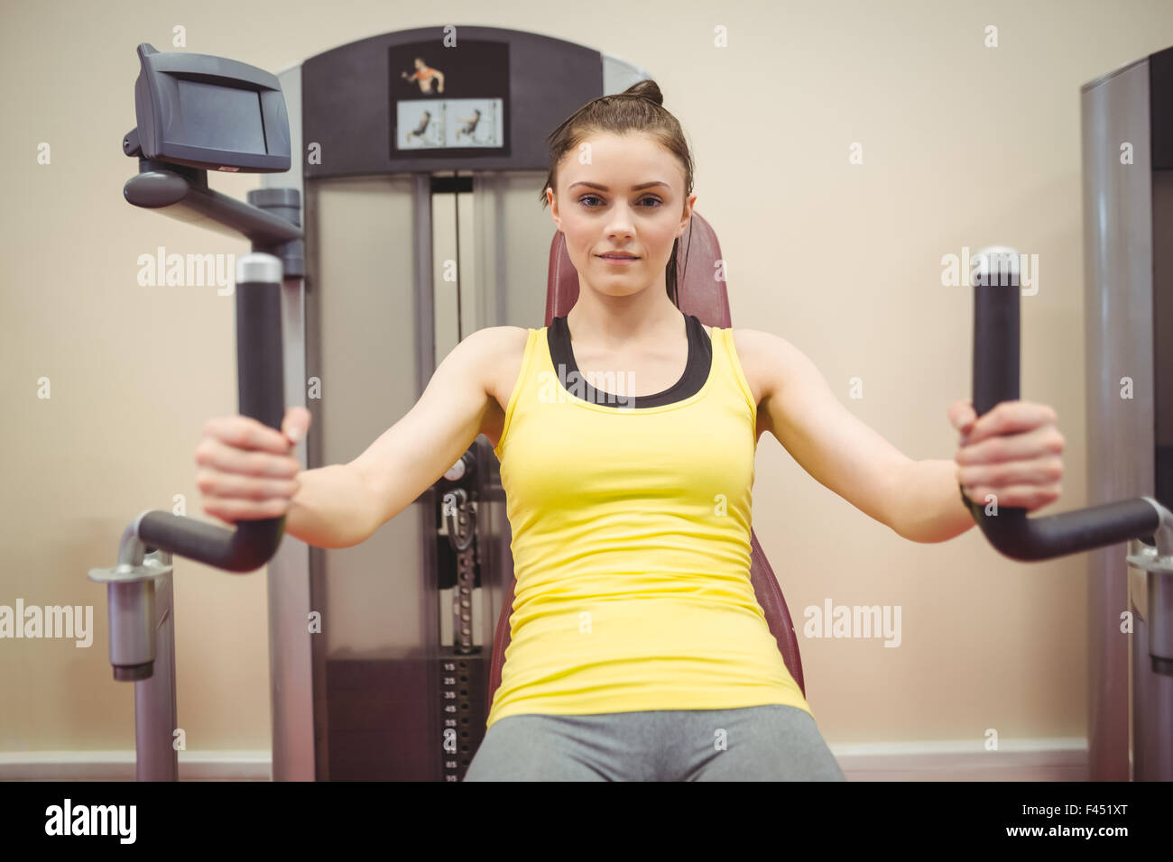 Fit woman using weights machine Stock Photo - Alamy