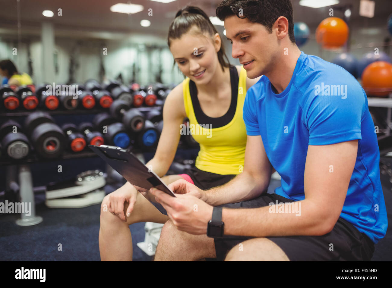 Trainer and client discussing her progress Stock Photo - Alamy