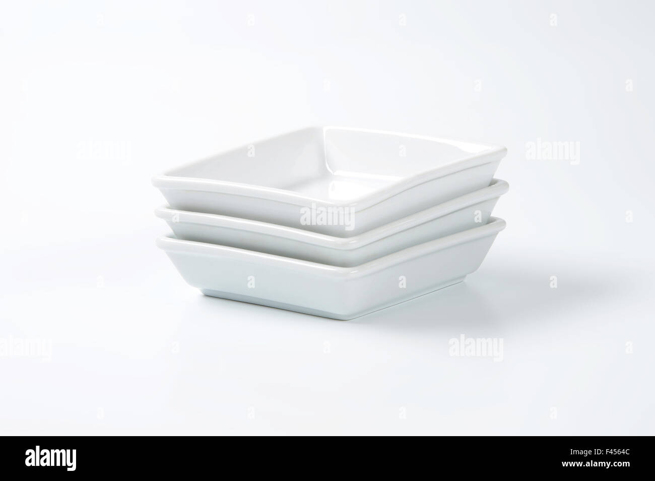 stack of white square plates on white background Stock Photo - Alamy