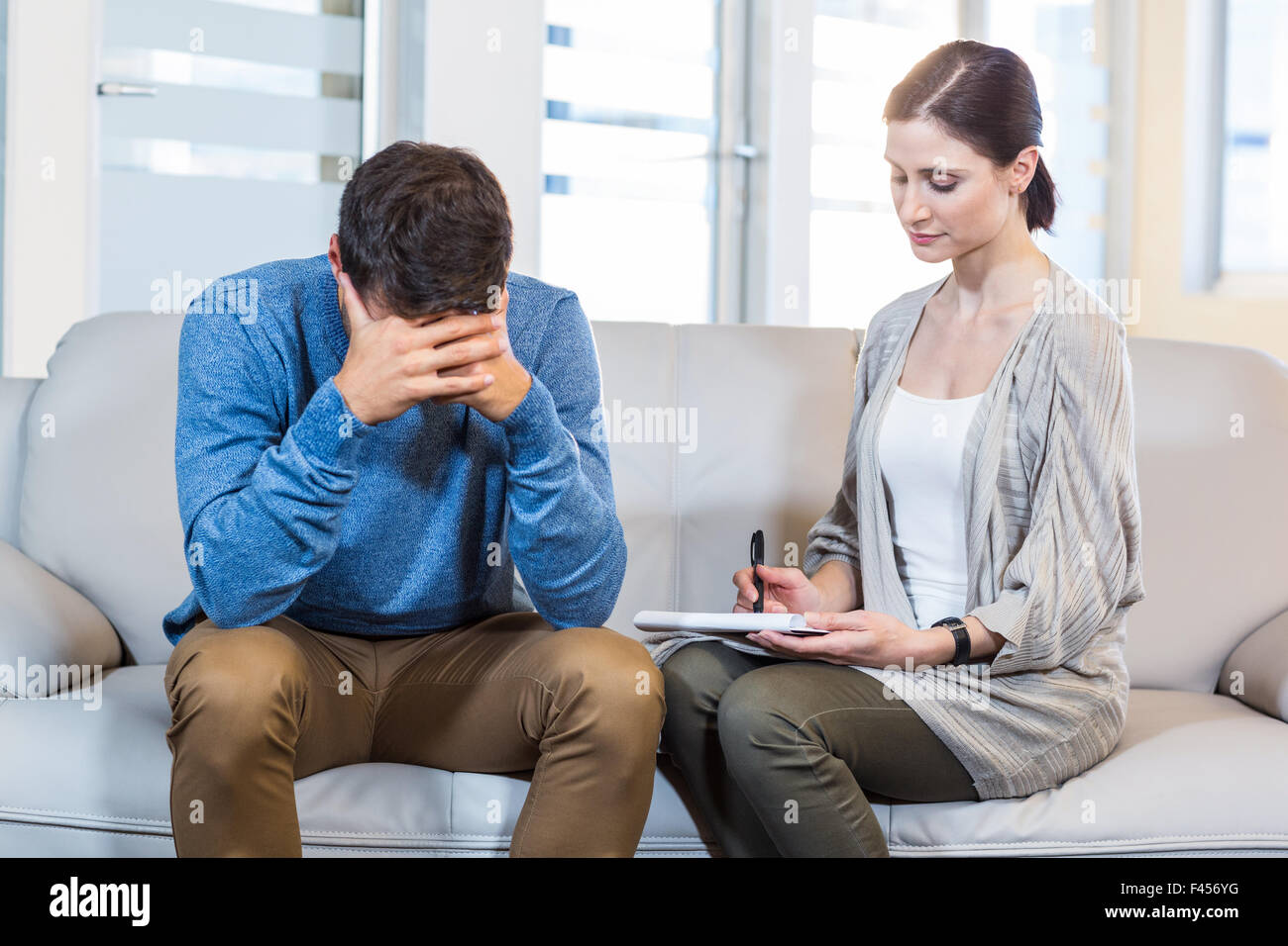 Psychologist talking with depressed man Stock Photo - Alamy