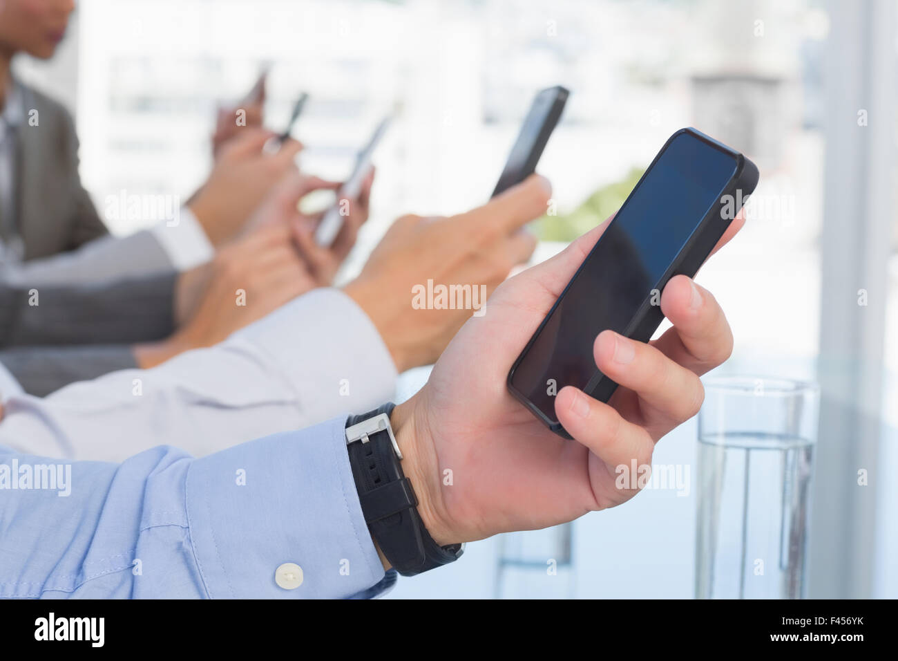 Business team using their mobile phone Stock Photo - Alamy