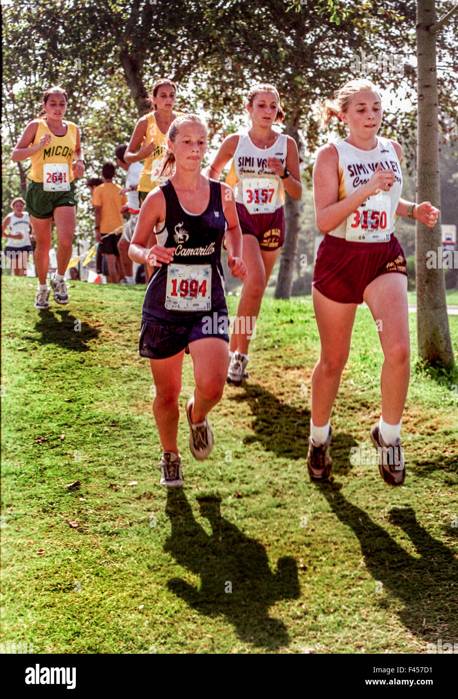 Multiracial teen girls from different high schools compete in a running ...