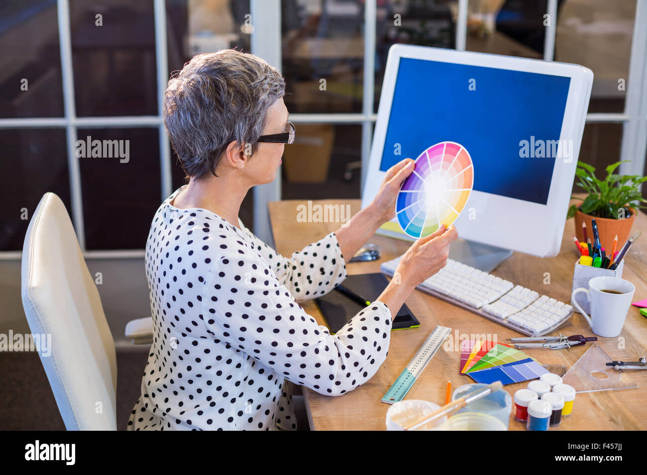 Casual businesswoman looking at colour chart Stock Photo - Alamy