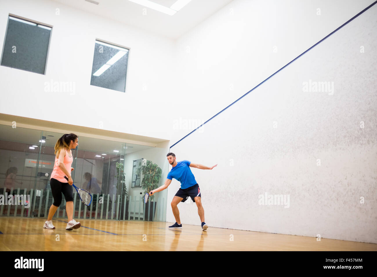 Couple playing a game of squash Stock Photo - Alamy