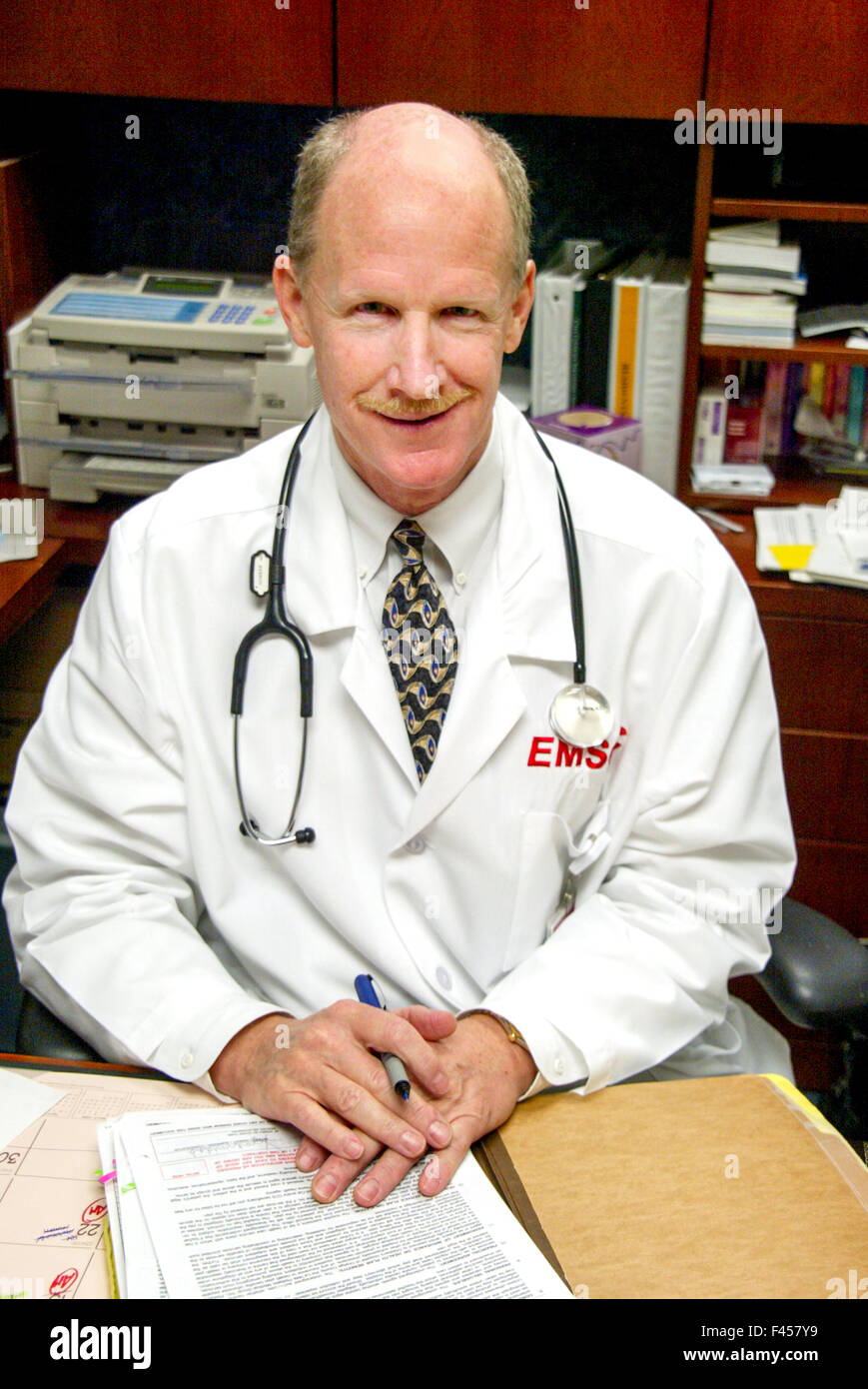 A friendly emergency room doctor wears his trademark white coat and ...