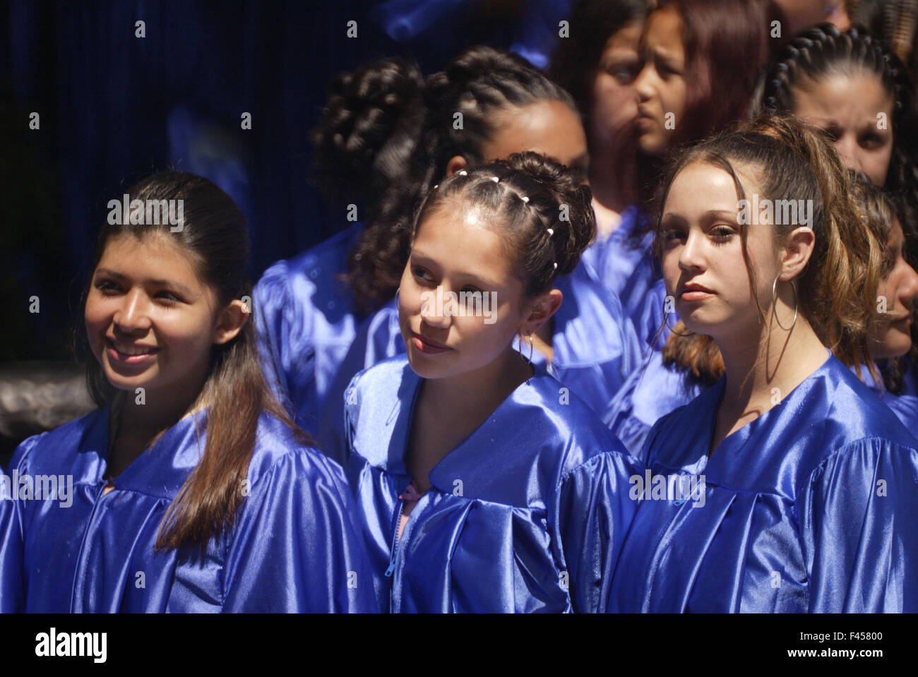 Hispanic and Caucasian middle school girls wearing blue graduation ...