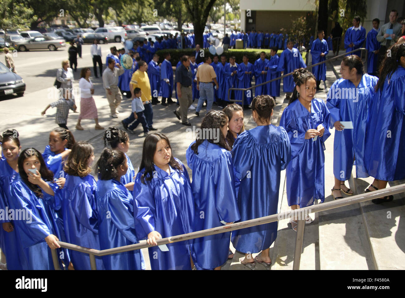 Hispanic and Caucasian middle school girls wearing blue graduation ...