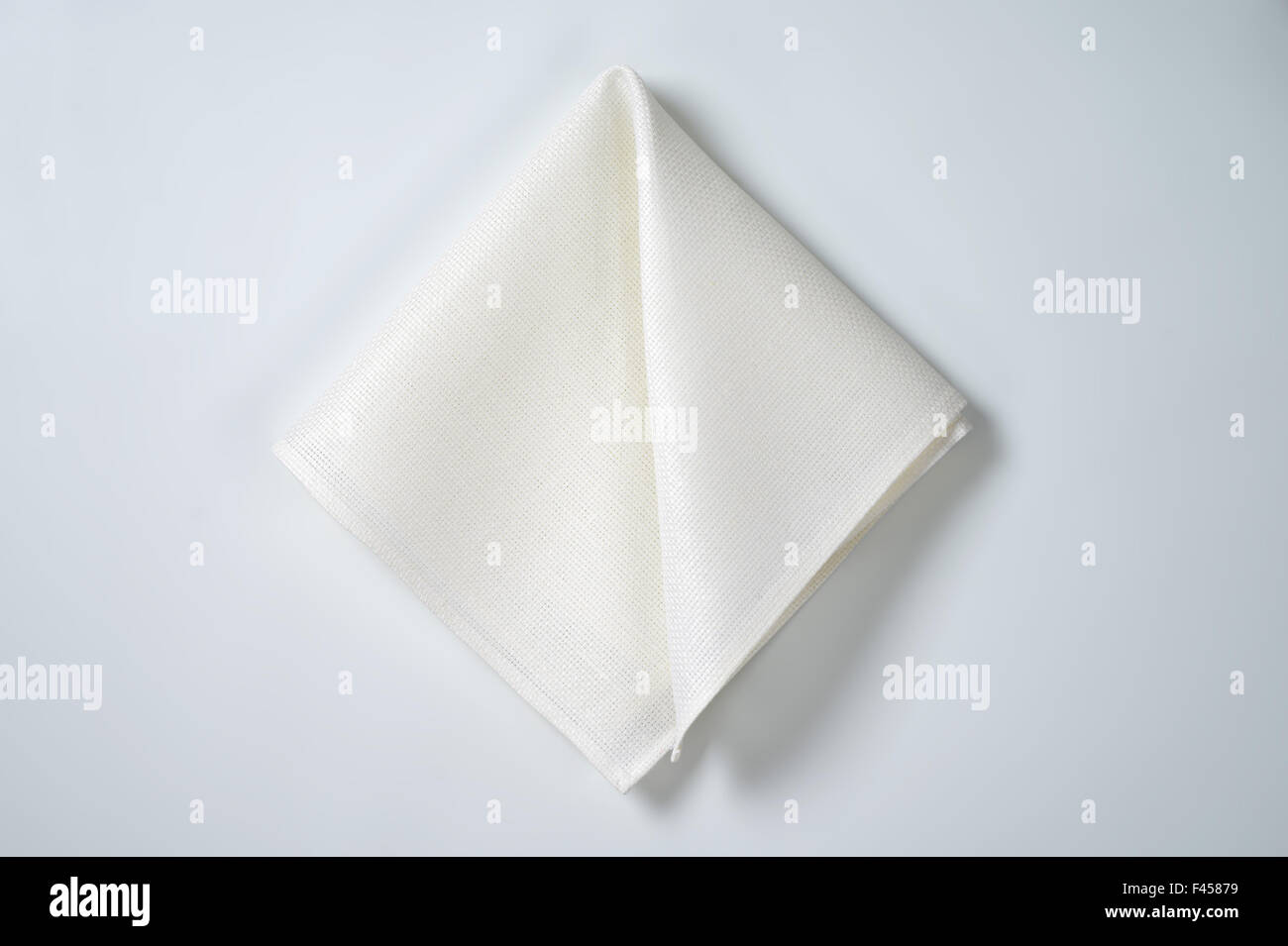 white folded napkin on white background Stock Photo - Alamy