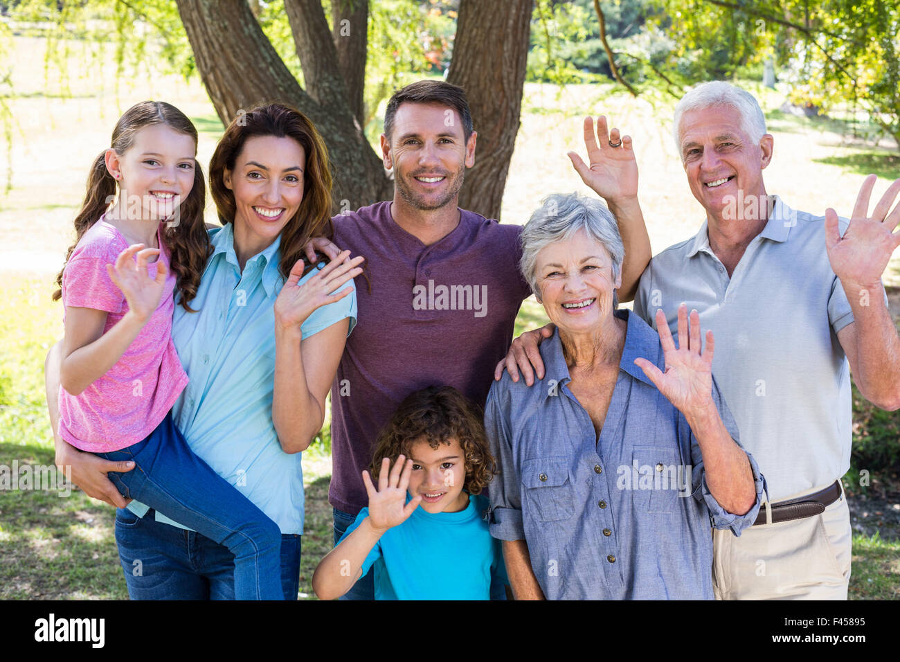 Extended family smiling in the park Stock Photo - Alamy