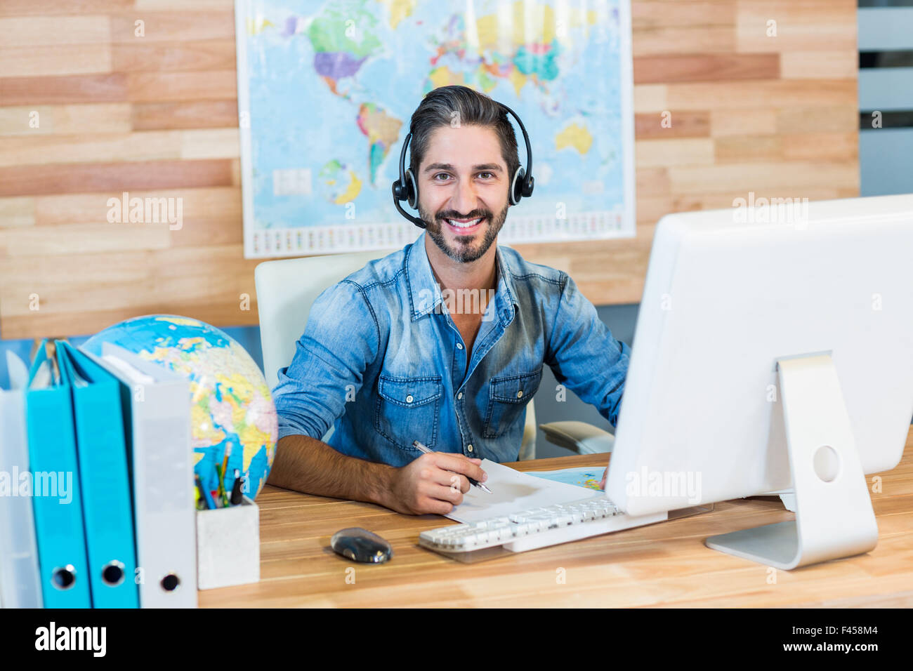 Smiling travel agent looking at camera Stock Photo - Alamy