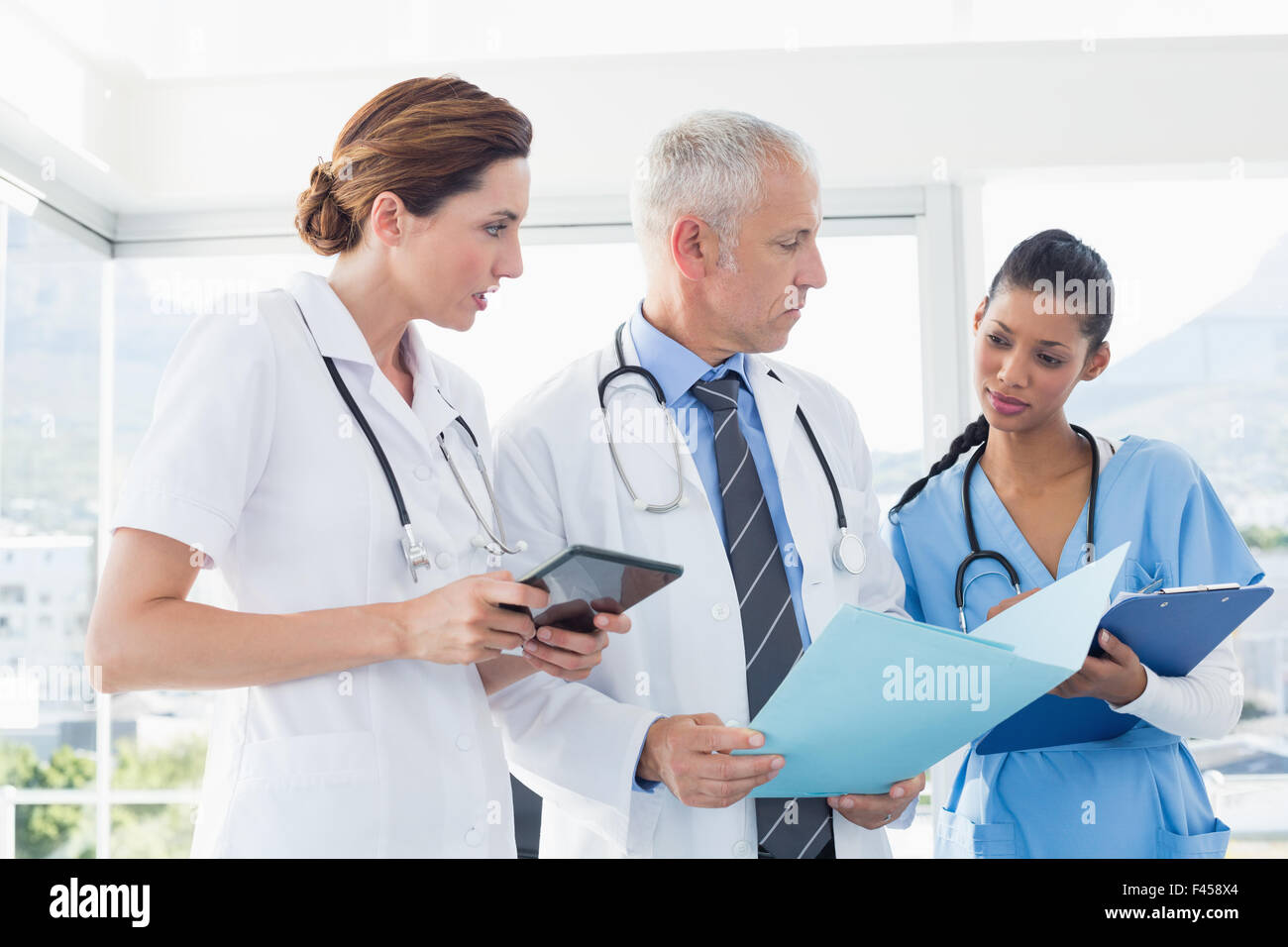 Doctors working together on patients file Stock Photo - Alamy