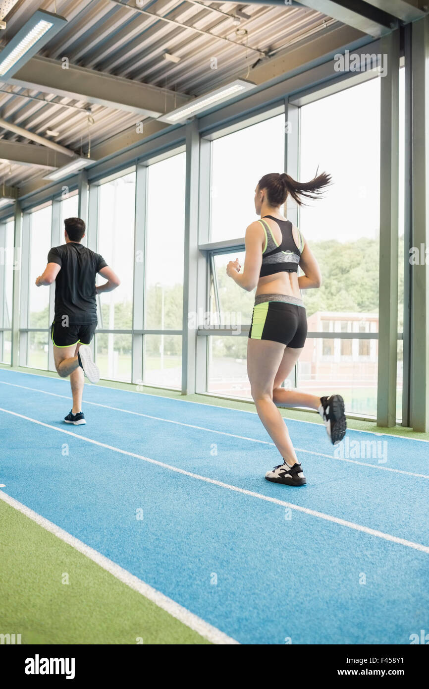 Couple running on the indoor track Stock Photo - Alamy
