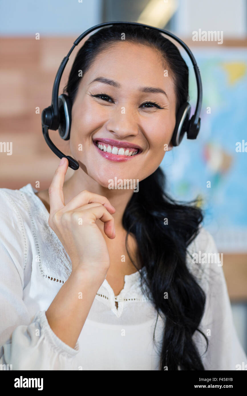 Pretty travel agent smiling at camera Stock Photo - Alamy