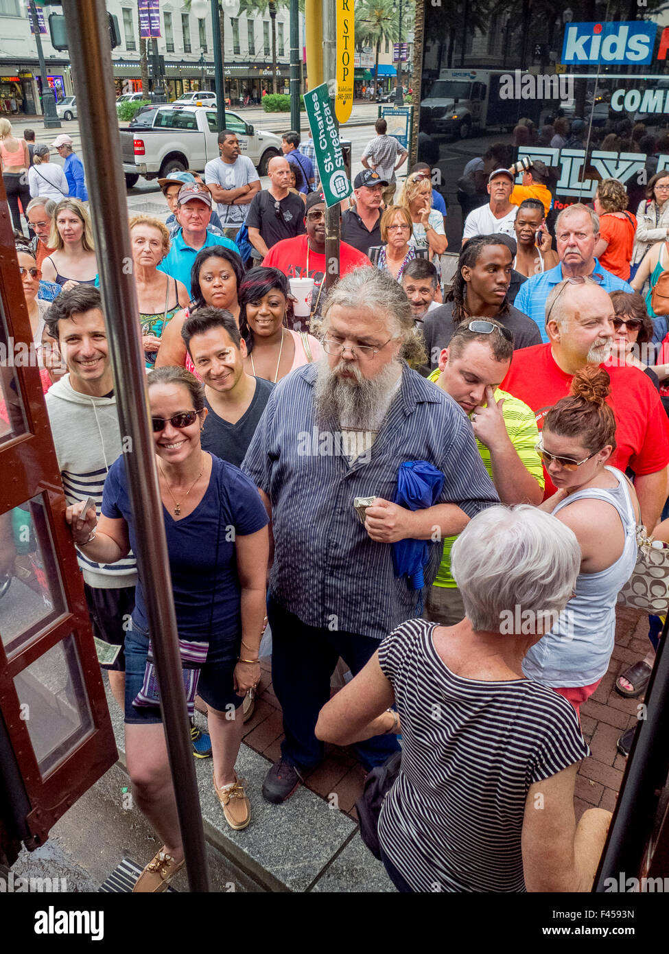 An eclectic multiracial crowd enters a trolley on Canal Street in New ...