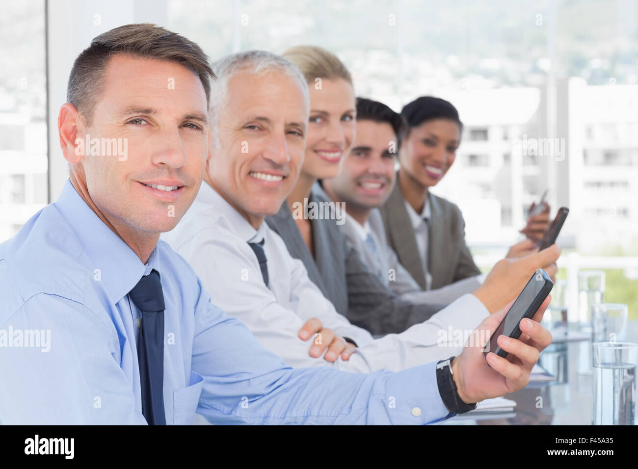 Business team using their mobile phone Stock Photo - Alamy