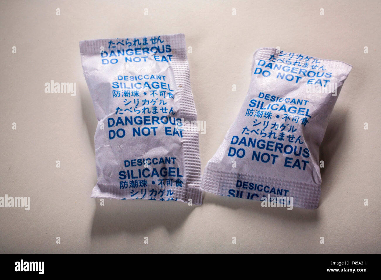 Two gas-permeable paper packages of moisture-absorbing silica gel ...