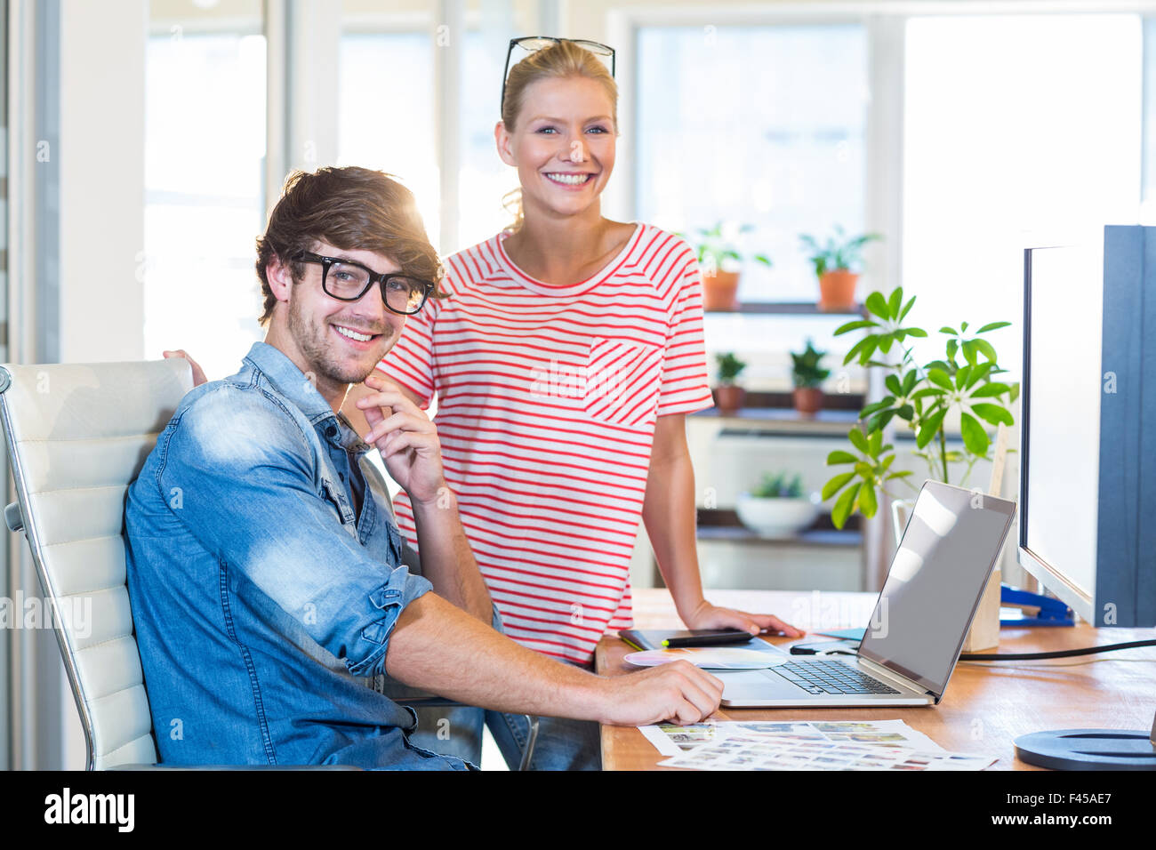 Smiling colleagues looking at camera Stock Photo - Alamy