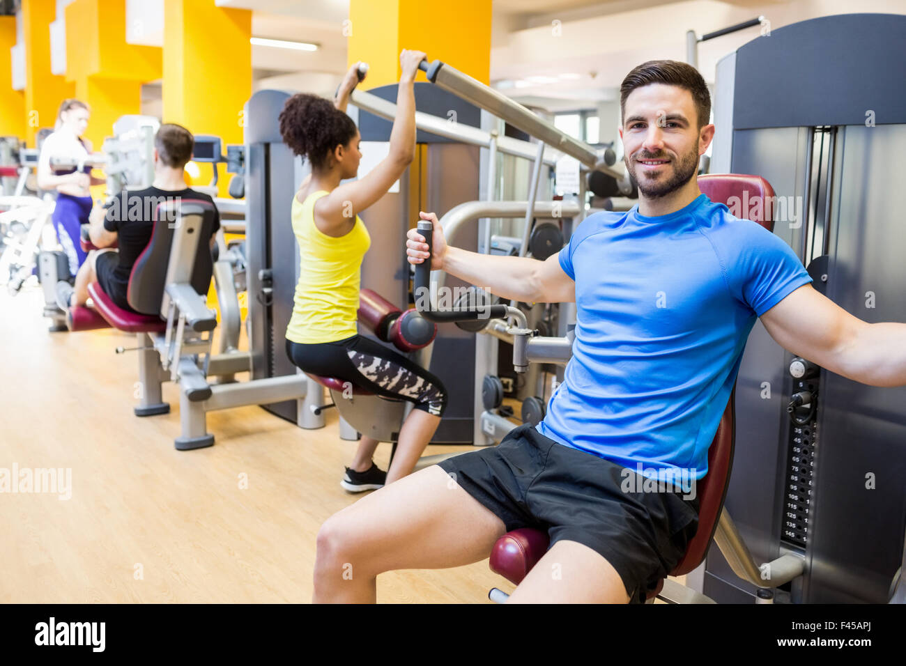 Fit people using weights machines Stock Photo - Alamy