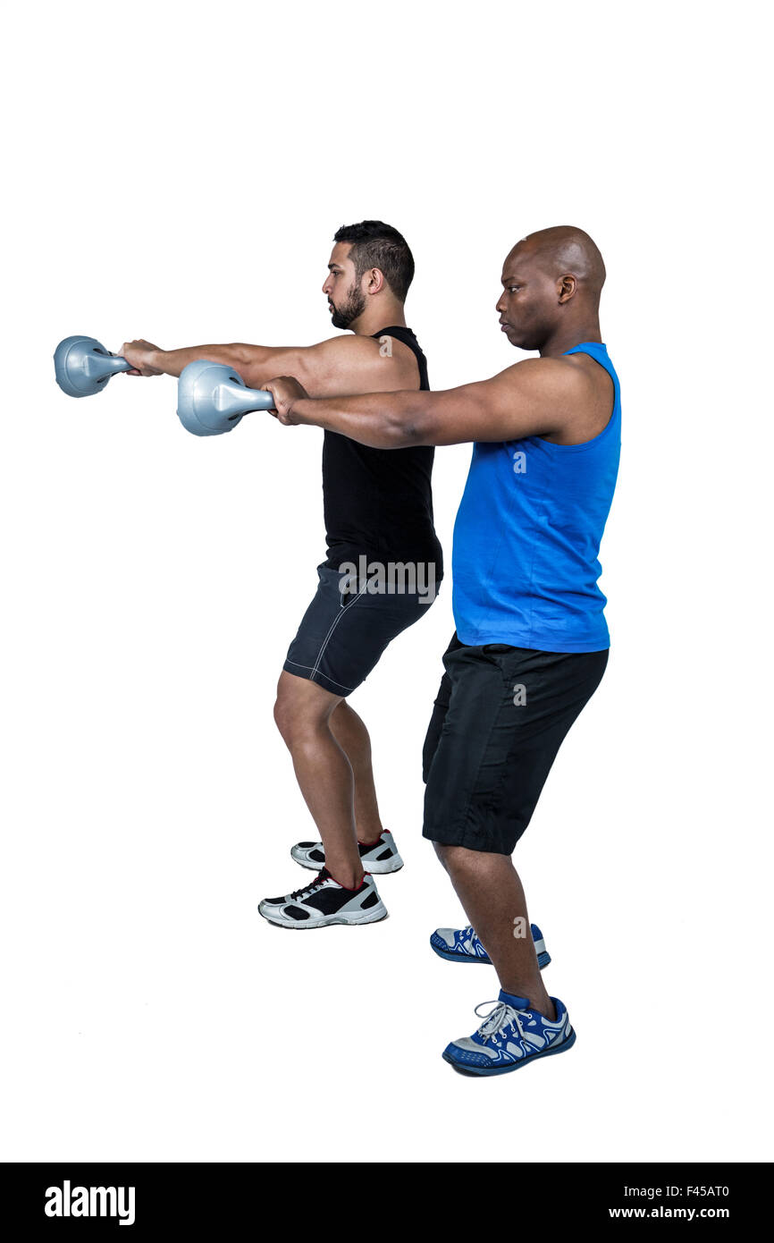 Strong friends lifting kettlebells together Stock Photo - Alamy